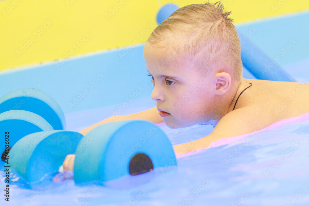 A boy with Down syndrome learns to swim in the pool, rehabilitation of ...