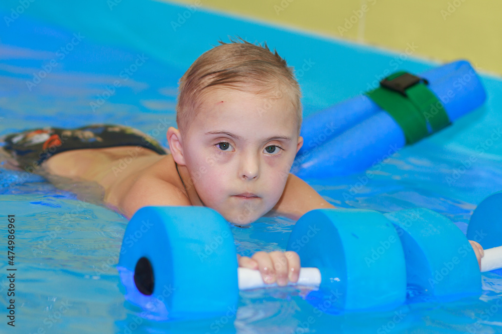 A boy with Down syndrome learns to swim in the pool, rehabilitation of ...