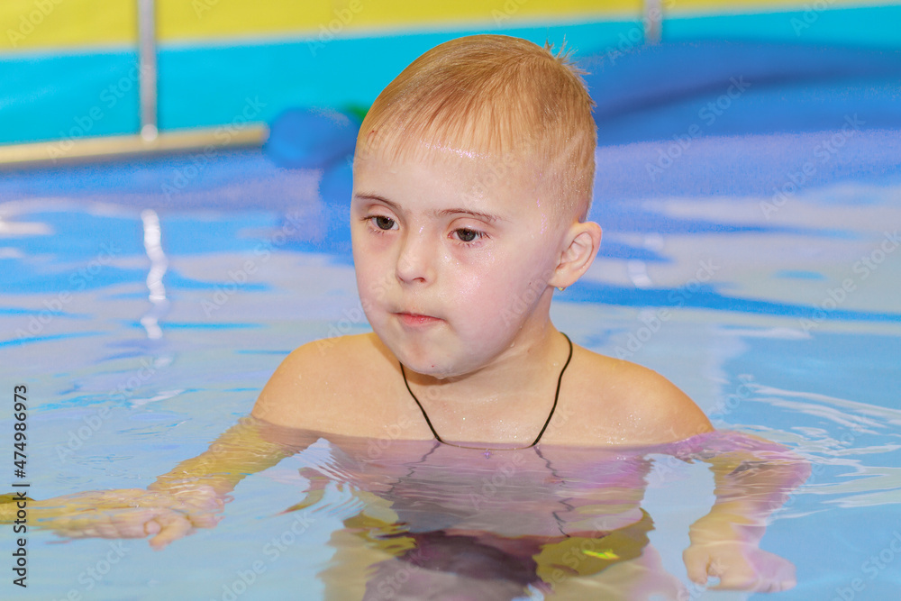 A boy with Down syndrome learns to swim in the pool, rehabilitation of ...