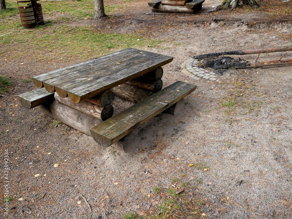 Picnic area in a public park with wooden bench and table and open fire ...