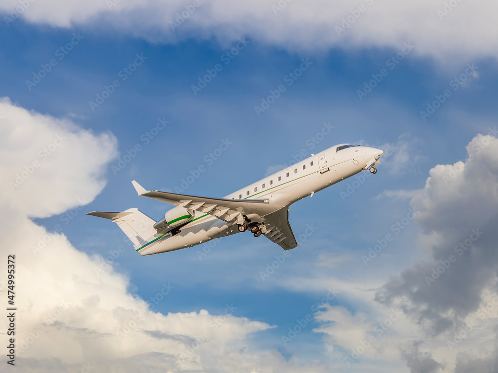 Takeoff of a business jet among beautiful clouds. A small white jet ...