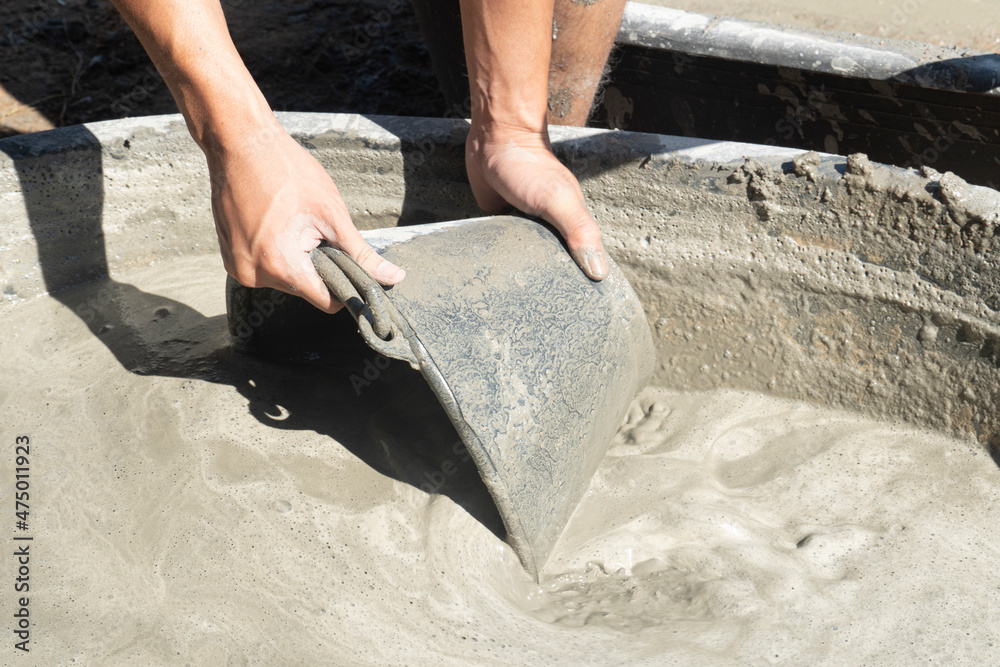 Construction worker : Use a bucket to scoop the ready-mixed cement with ...