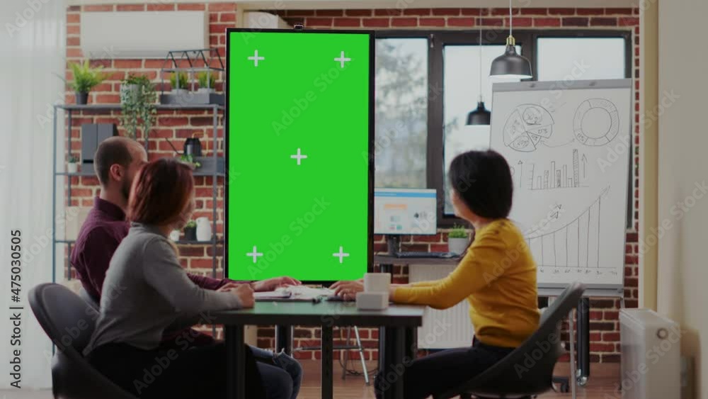 Team of people looking at monitor with green screen in business office ...