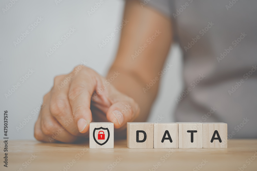 DATA text on wooden cubes with hand holding protect shield symbol and ...