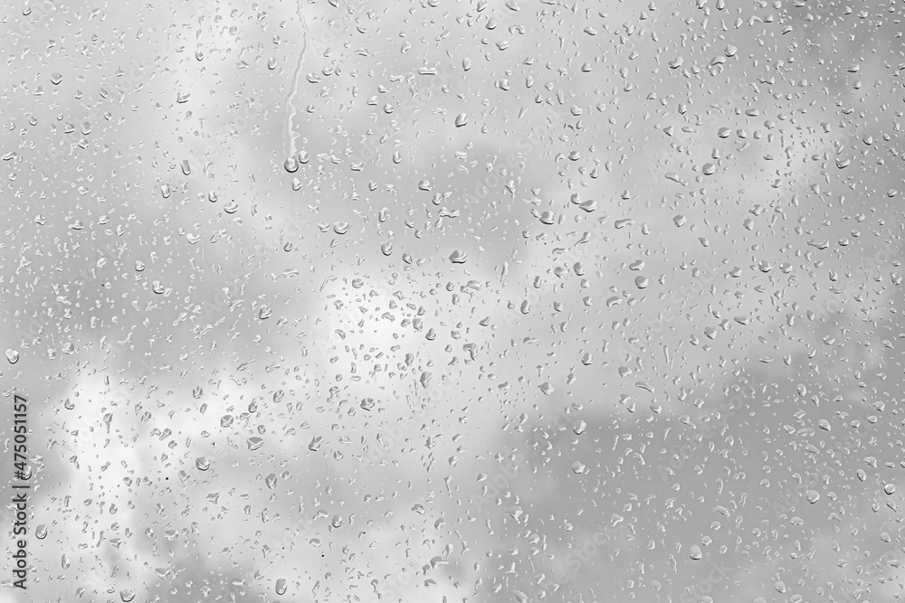 Rain drops on window glasses surface with gray sky background. Natural ...