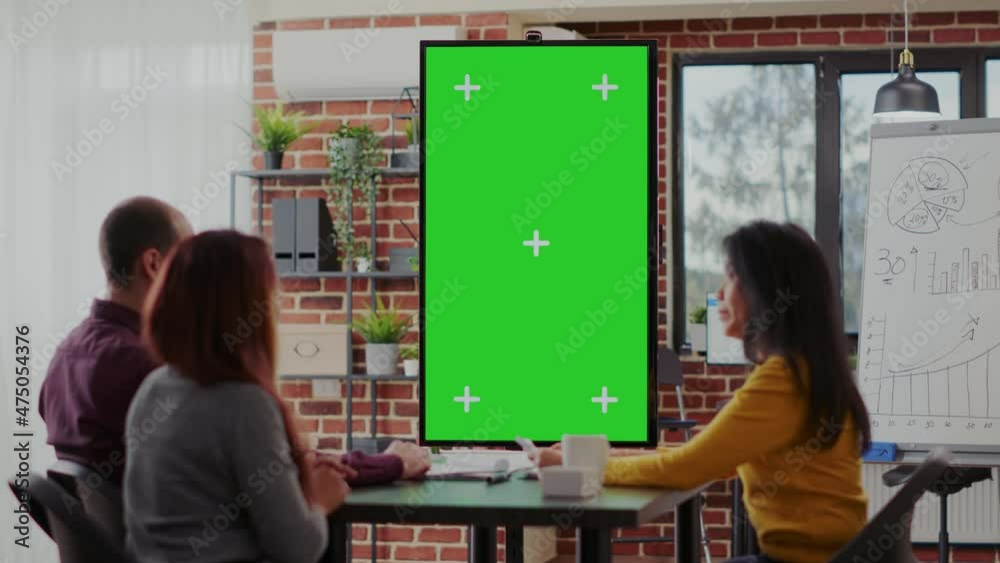 Employees using green screen on monitor vertically in boardroom ...
