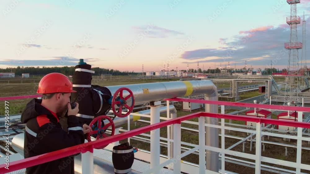 An employee of the oil and gas industry on tanks for cleaning oil from ...