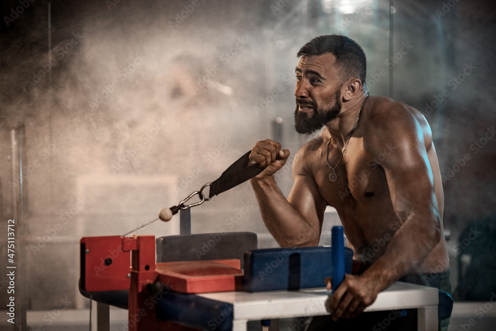 Strong athlete in the gym training for arm wrestling sparring ...