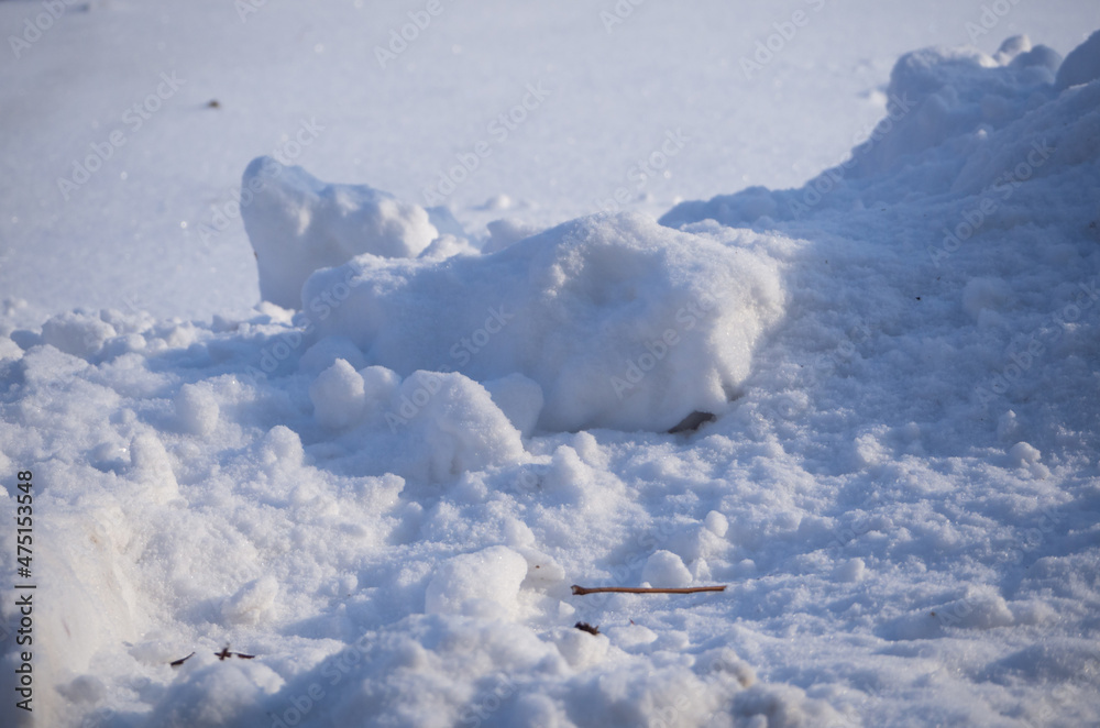 Natural snow piled in a pile with lumps and garbage. Blue-white lumps ...