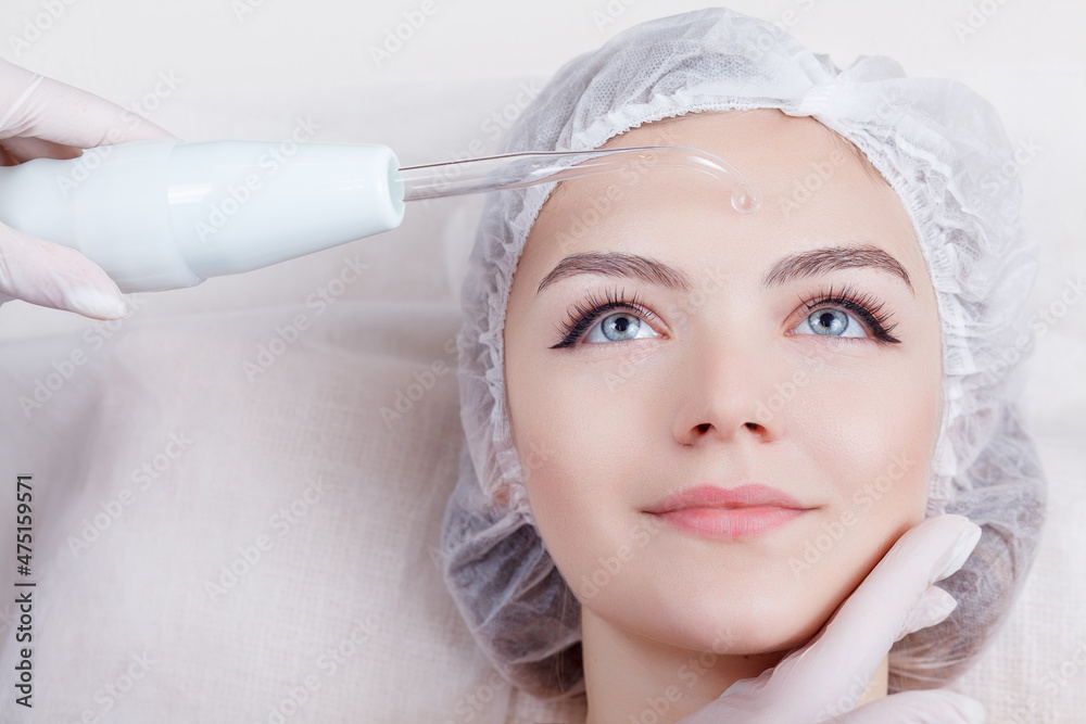 High frequency machine in spa salon. Young woman receiving electric ...