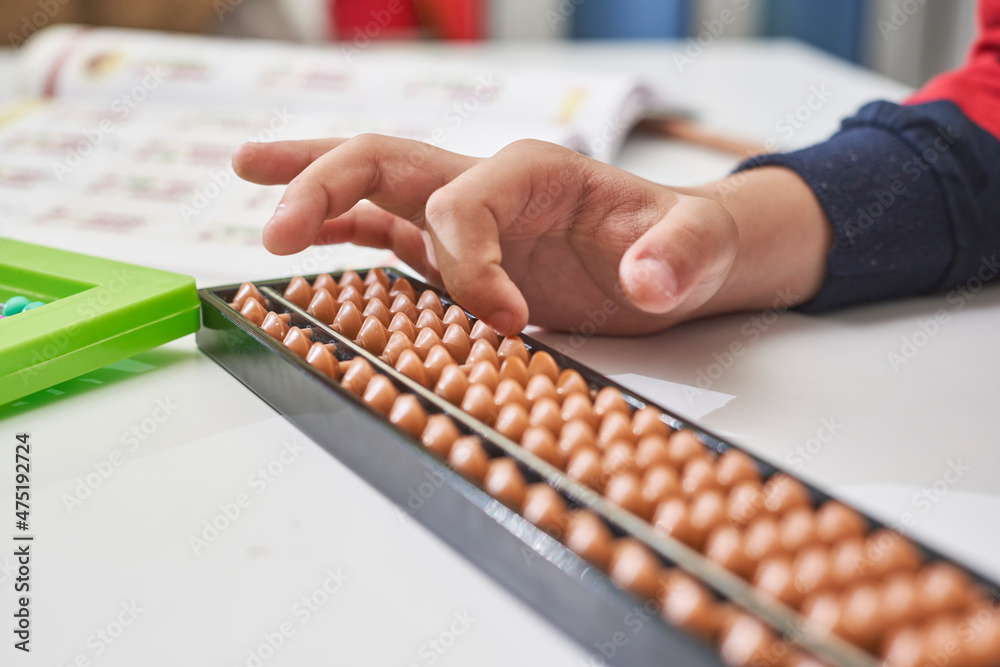Doing mental math or mental arithmetic. Hand of little boy using abacus ...