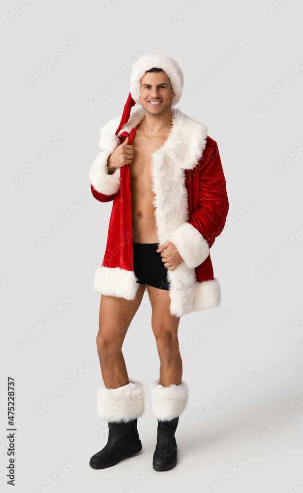 Sexy young man in Santa costume on light background Stock Photo | Adobe ...