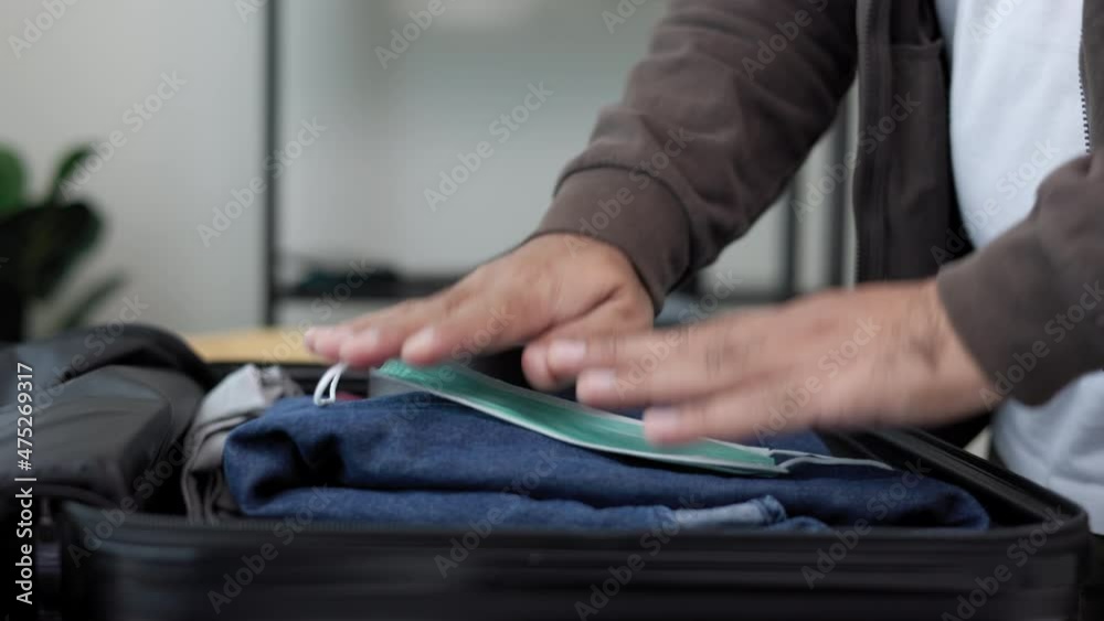 Close up male hands organize luggage with virus protection mask and ...