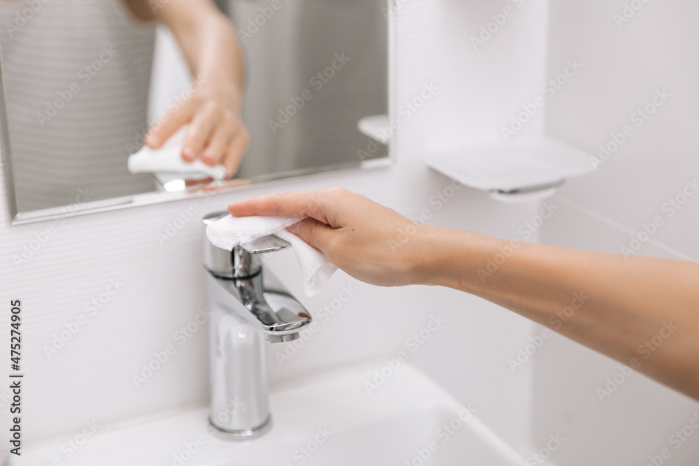 Cleaning the sink faucet with a microfiber cloth. Cleaning the bathroom ...