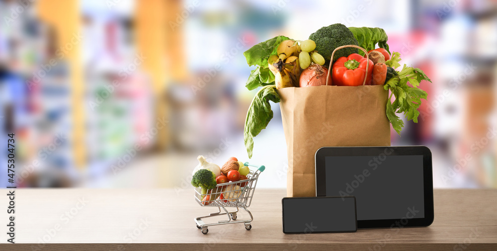 Poster Online shopping background with devices and shopping bag in ...