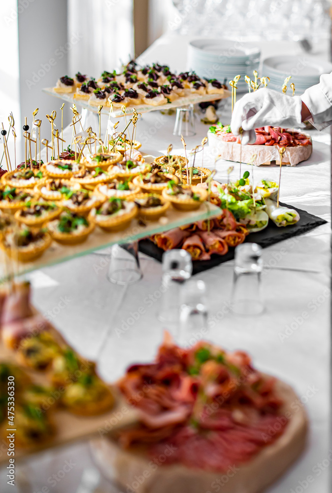 woman hands of a waiter prepare food for a buffet table in a restaurant ...