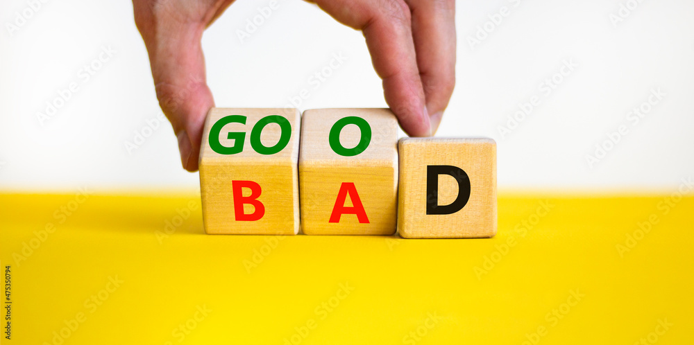 Good or bad symbol. Businessman turns wooden cubes and changes the word ...