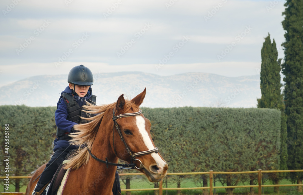Young boy horse riding at the ranch. Stock Photo | Adobe Stock