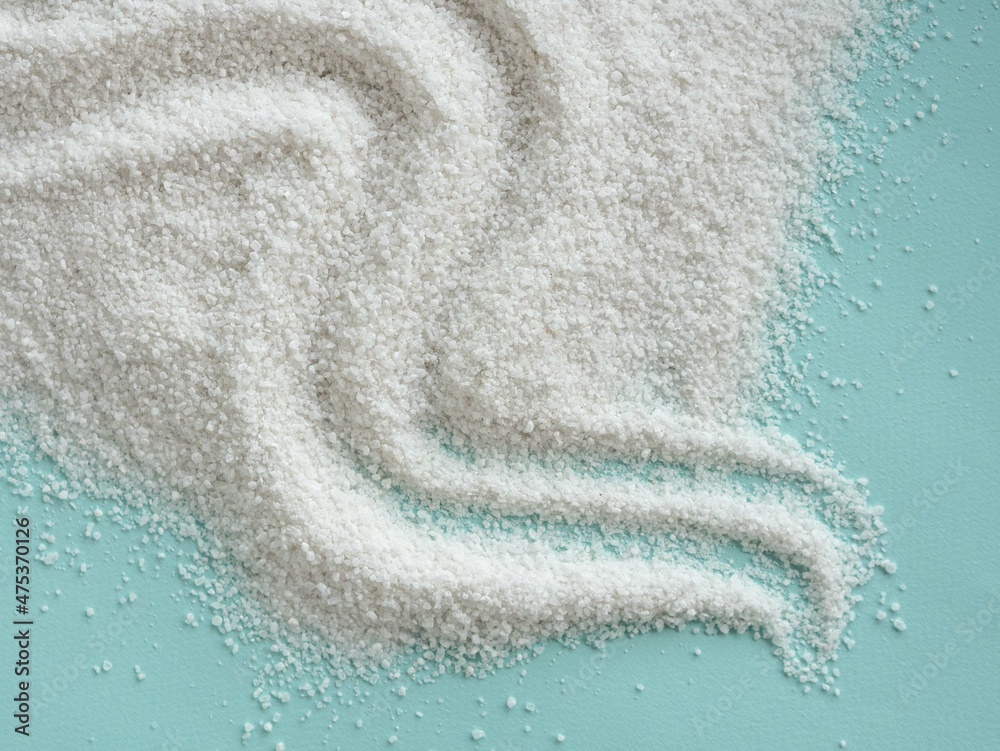 Sea salt scattered on a blue background, texture waves top view. Salt ...