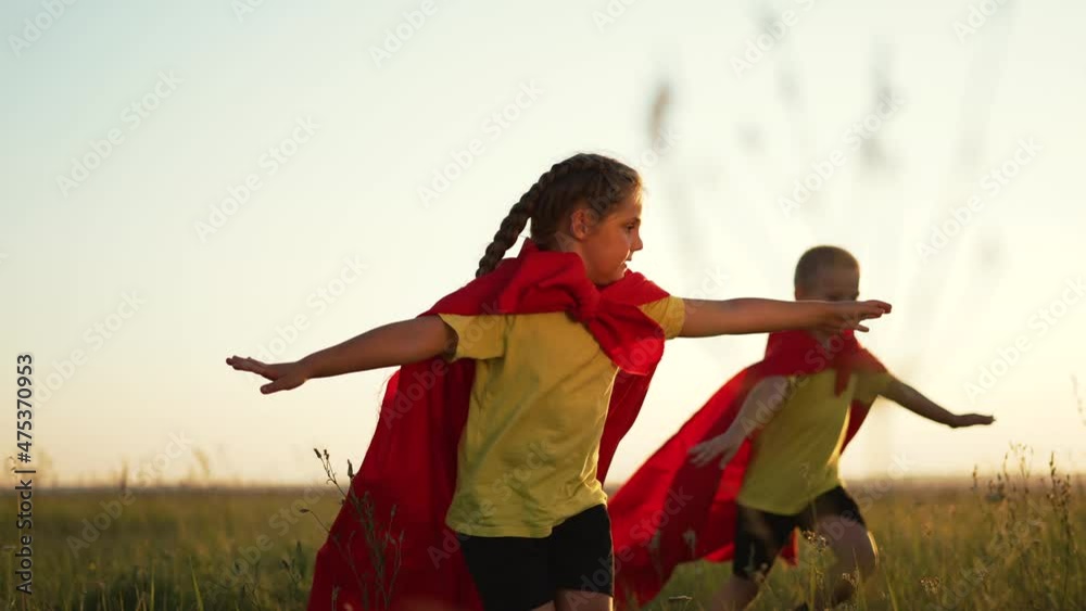 Superheroes girl and boy.Children in green grass.Cute happy family in ...