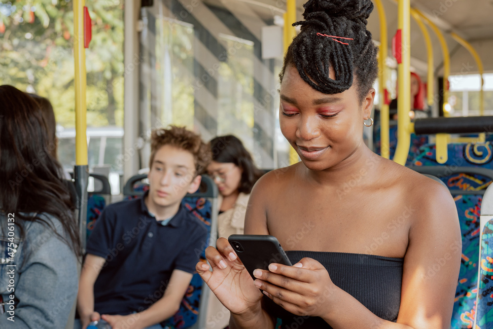 Dark-skinned beautiful woman with dreadlocks tied up in bun sits on ...