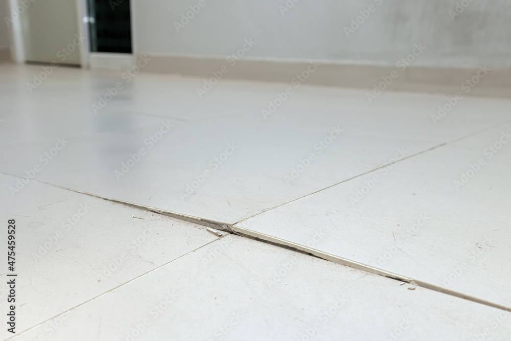 Ceramic tiles floor cracked and broken from concrete inflate in house ...