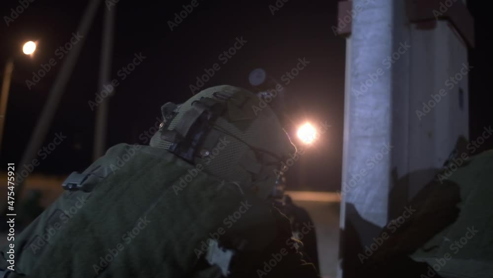 Close up of the back of an israeli soldier pointing his rifle covering ...