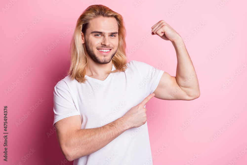 Photo of attractive young positive man point finger biceps fist flex ...