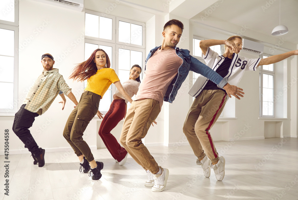 Hip hop dance crew rehearsing in modern light studio. Smiling young ...