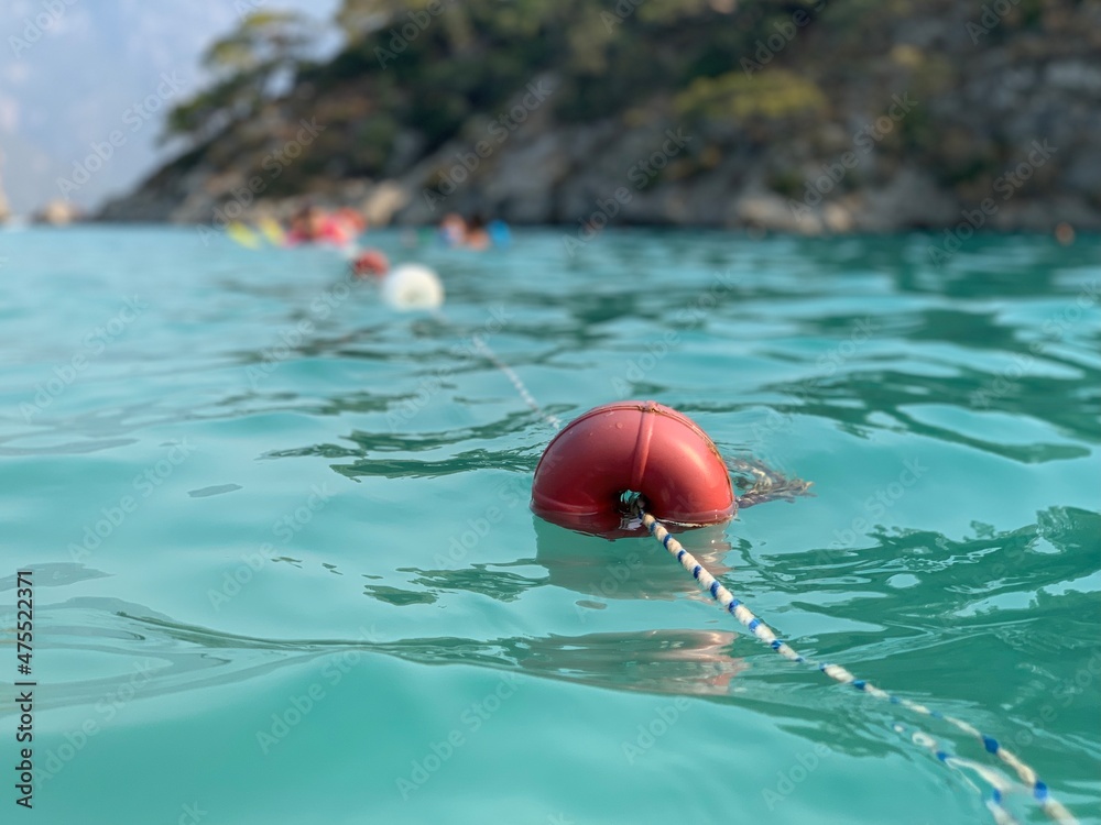 Beach buoys on a rope in the sea. A marker for swimming in blue water ...
