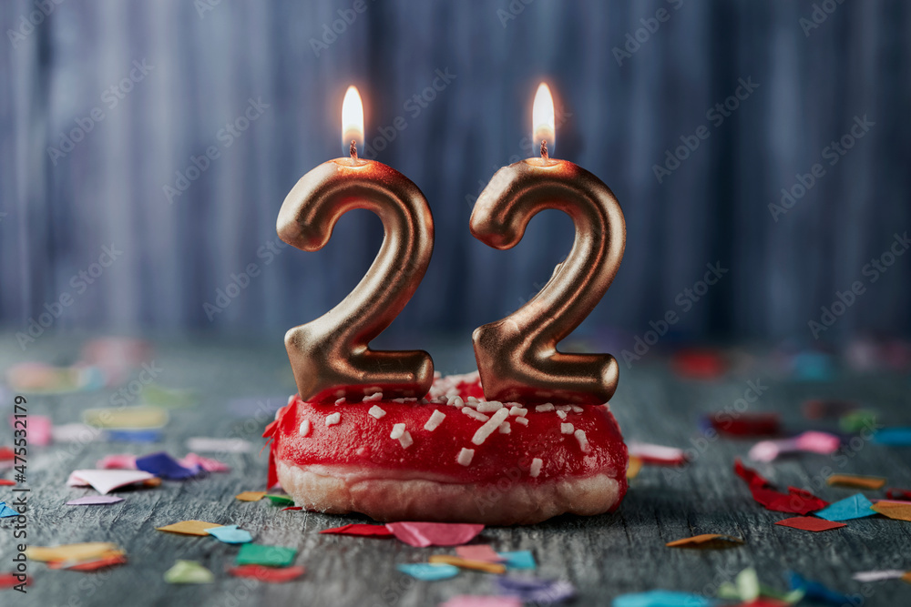 lit candles in the shape of number 22 in a cake Stock Photo | Adobe Stock