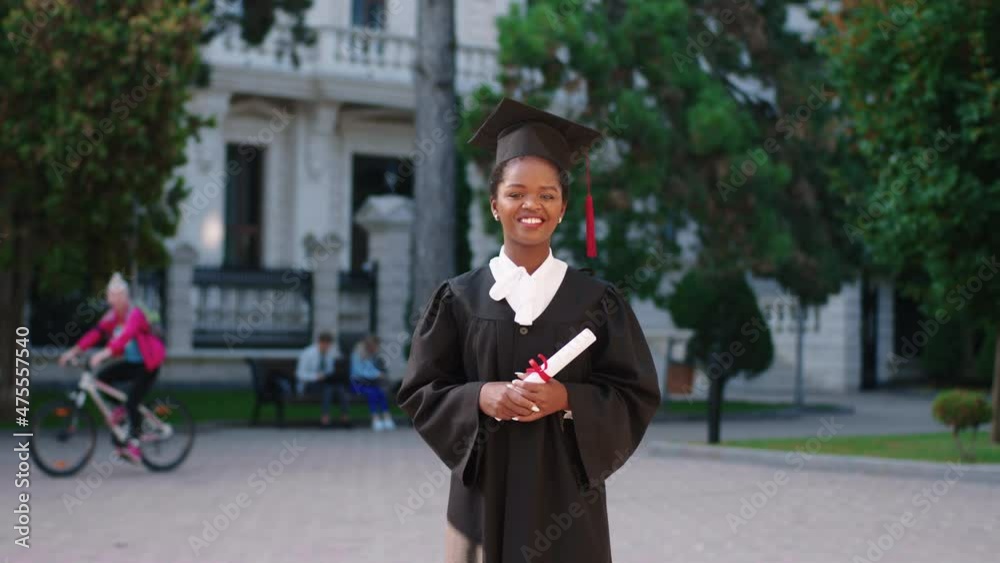 Beautiful black woman graduate posing with her diploma in front of the ...