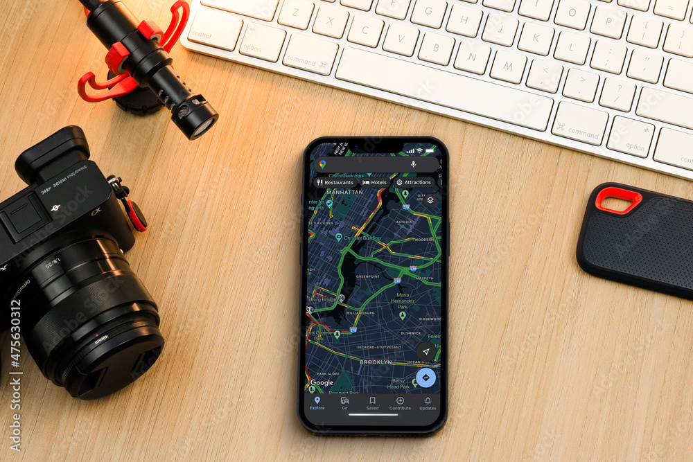 Google Maps app on smartphone iPhone 13 screen on wooden table. Content ...