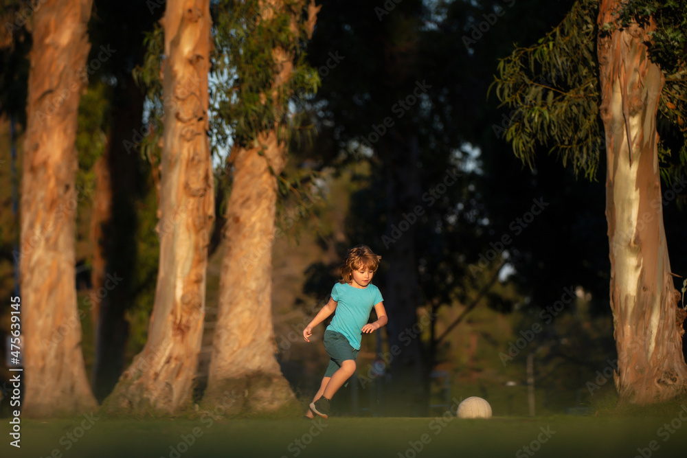 Boy child playing football on football field. Kid playing soccer. Child ...