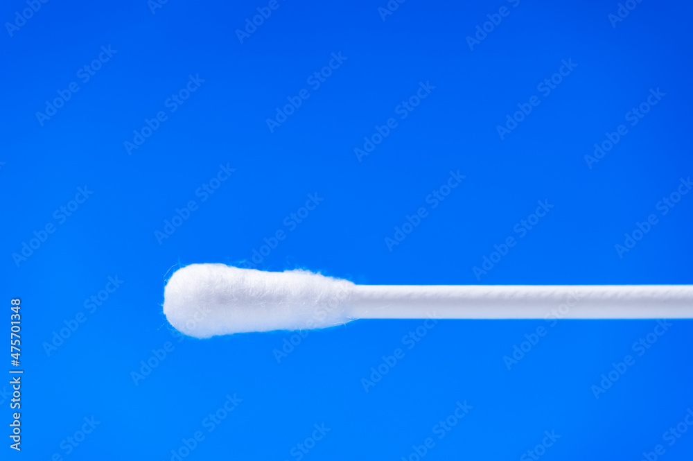 White cotton swab or or cotton bud with copy space against blue ...