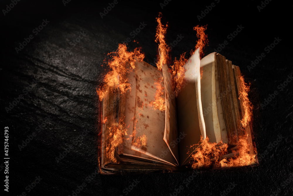 Open old book with burning pages on dark background Stock Photo | Adobe ...