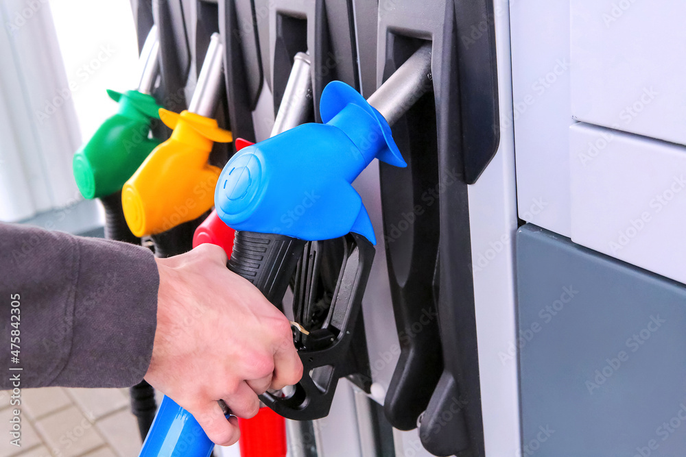 Detail of a petrol pump in a petrol station.Close up on fuel nozzle in ...