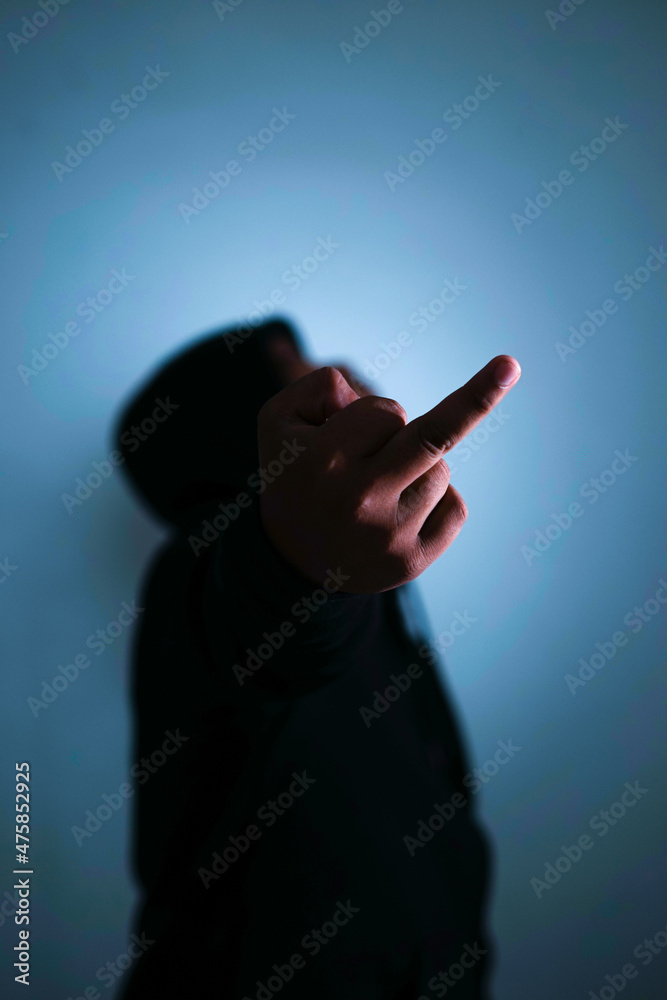 Fotografia do Stock: an unidentified man wearing a black hoodie puts up ...