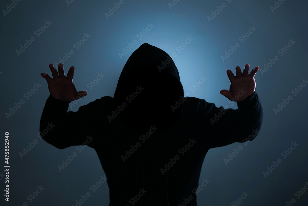 a silhouette of a man with a hoodie. a portrait of an unidentified ...