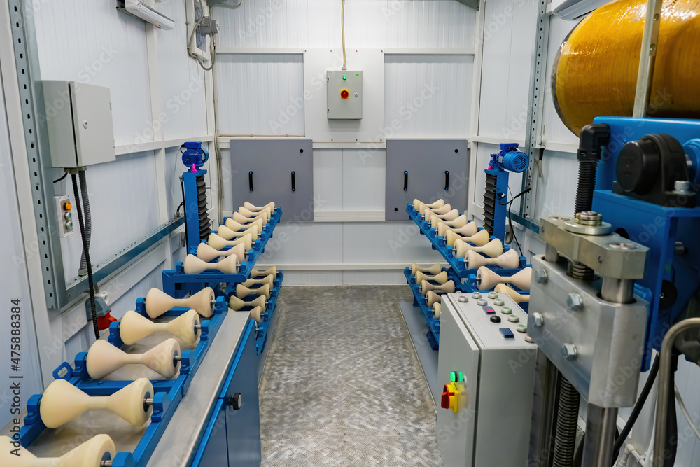 Room with many pipe rollers. Tube cone conveyor. Rollers for moving and ...