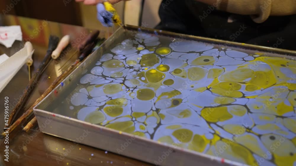 Vidéo Stock hands draws with paints on the water surface. Turkish ...
