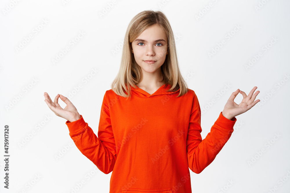 Calm and patient child, little girl meditating and breathing calmly ...