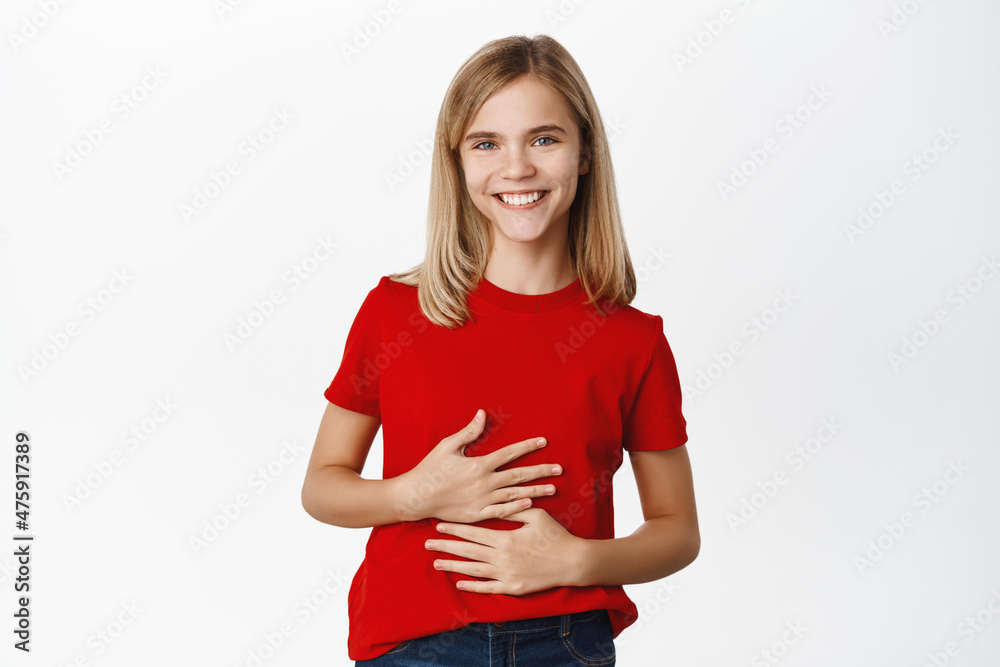 Smiling satisfied cute little girl, rubbing her belly stomach and ...
