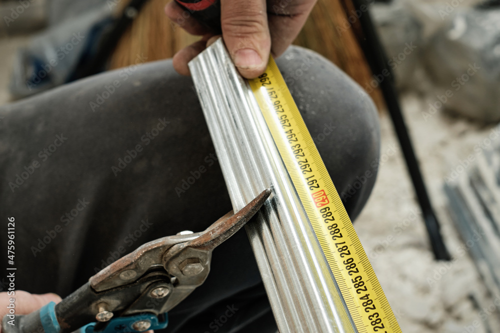 Specialist prepares steel profiles for drywall, close-up, selective ...