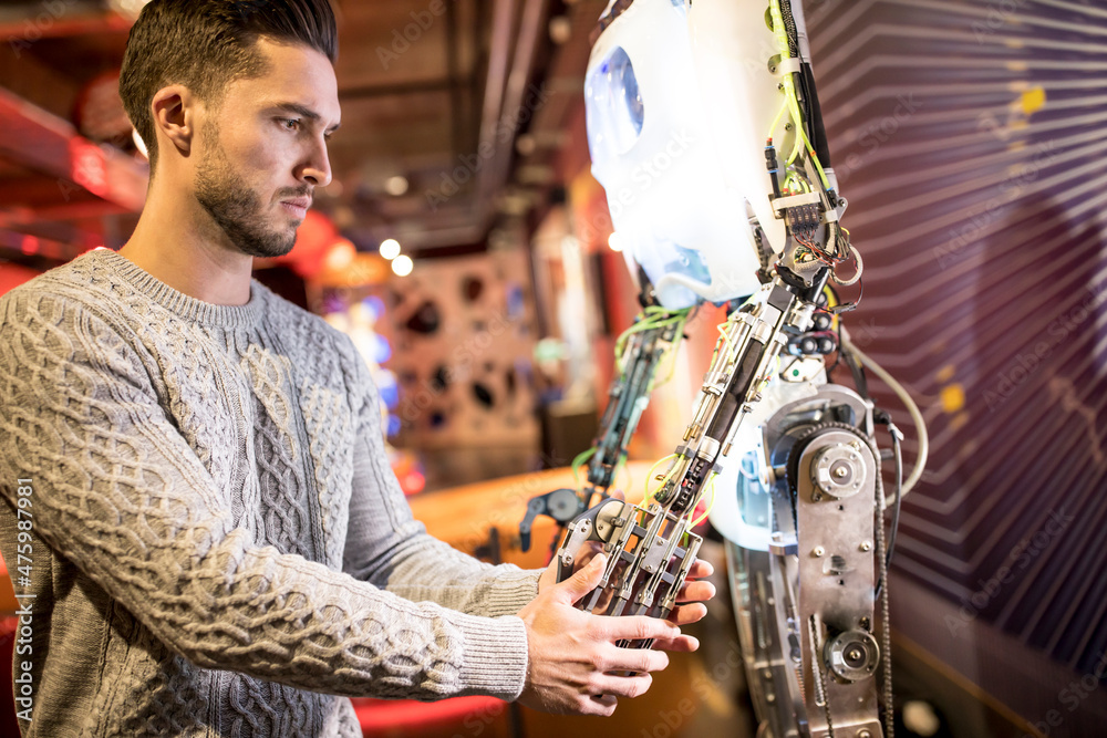 Engineer doing handshake with human robot at workshop Stock Photo ...