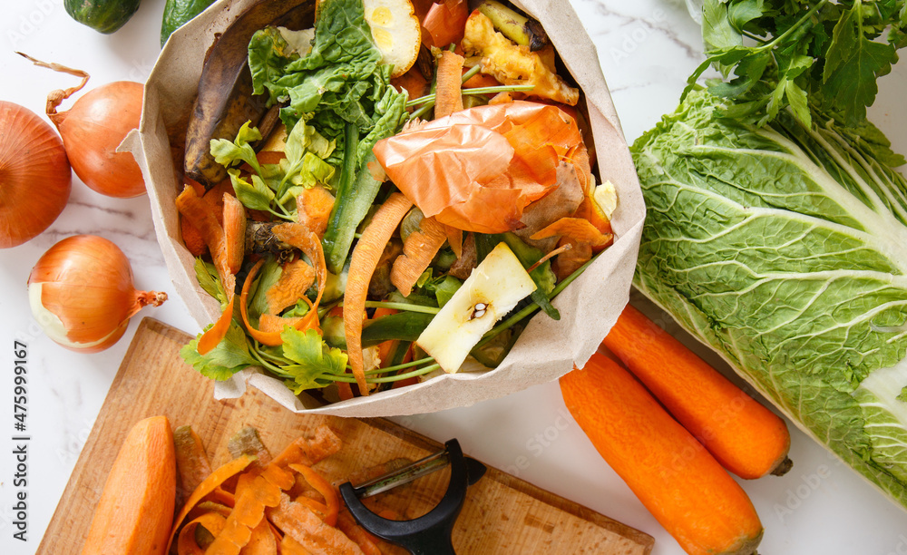 Sorted kitchen waste in paper eco bag on kitchen counter top. Compost ...