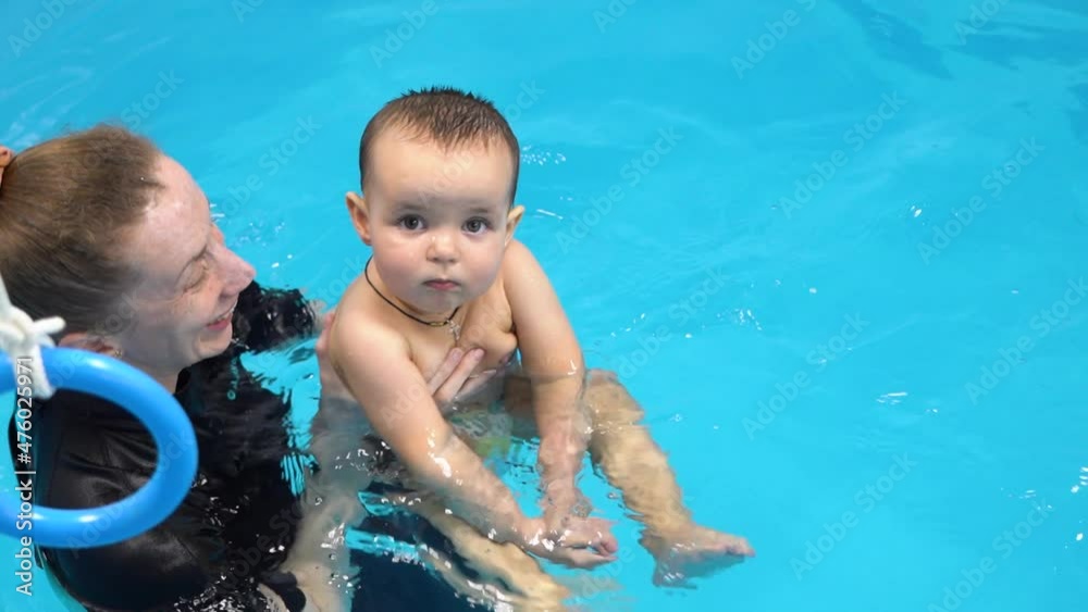 Newborn child looks up in surprise at the camera during a workout in ...