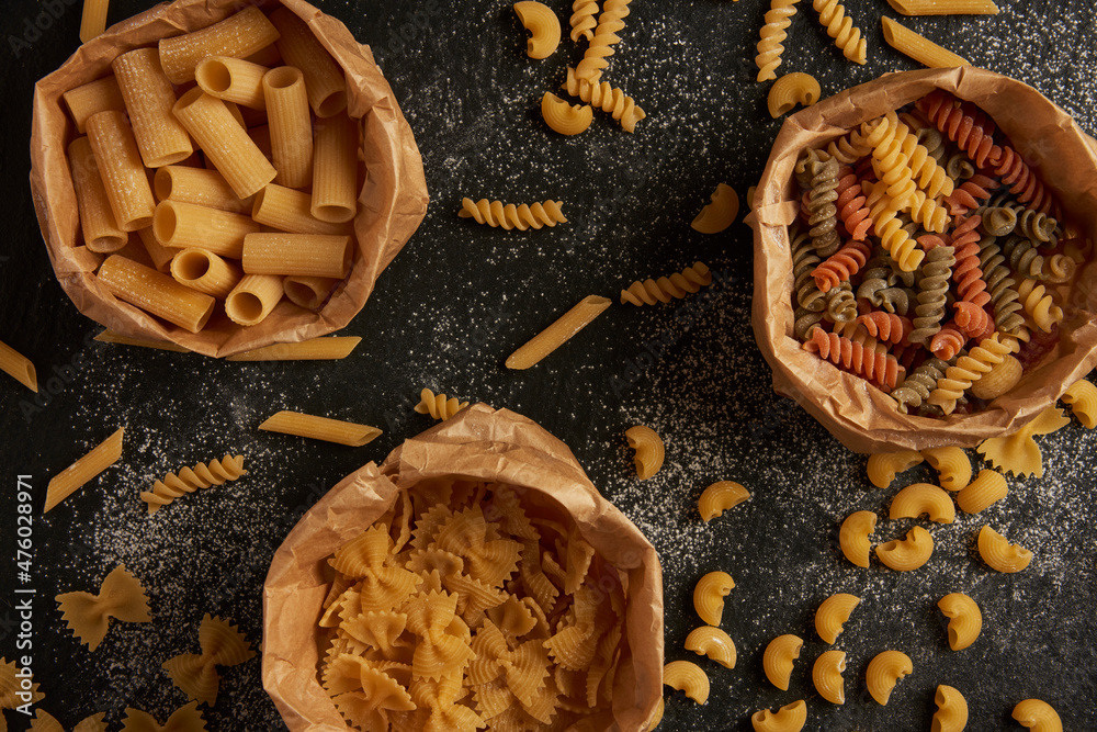 pasta concept three types of pasta put into paper bags on the black ...