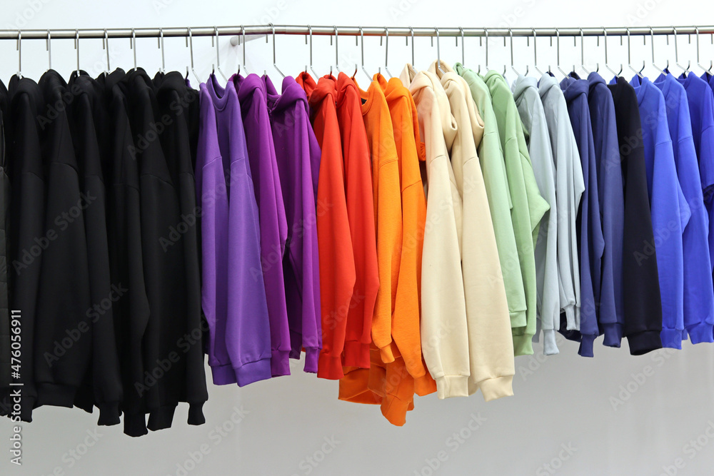 The clothes on the hanger are of different colors, all the colors of ...