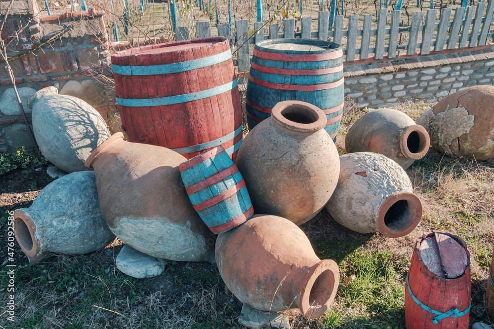 Group of Georgian traditional jug for wine qvevri and colored barrels ...